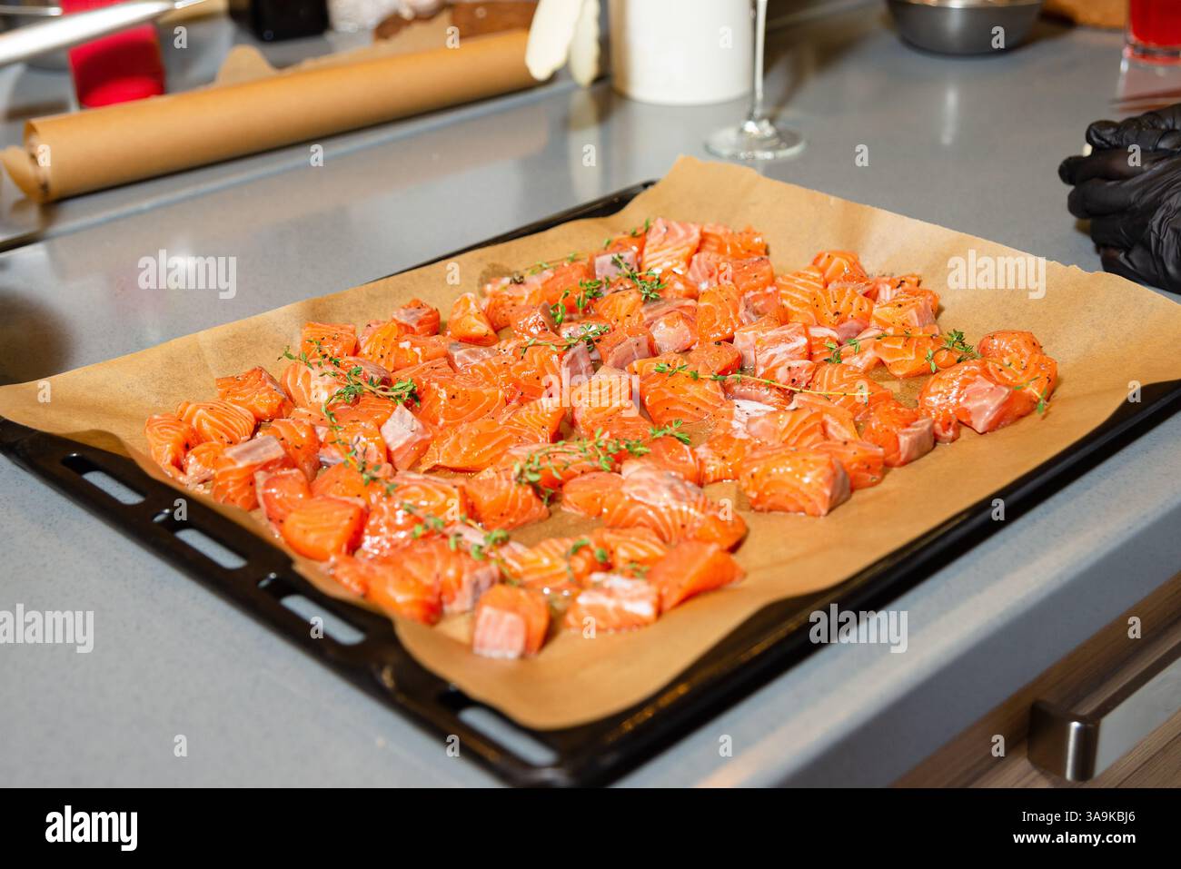 Freshly cut salmon cubes arranged on parchment paper, seasoned and ...