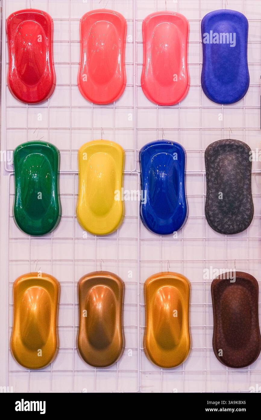 A row of colorful car paint samples are displayed on a white background ...
