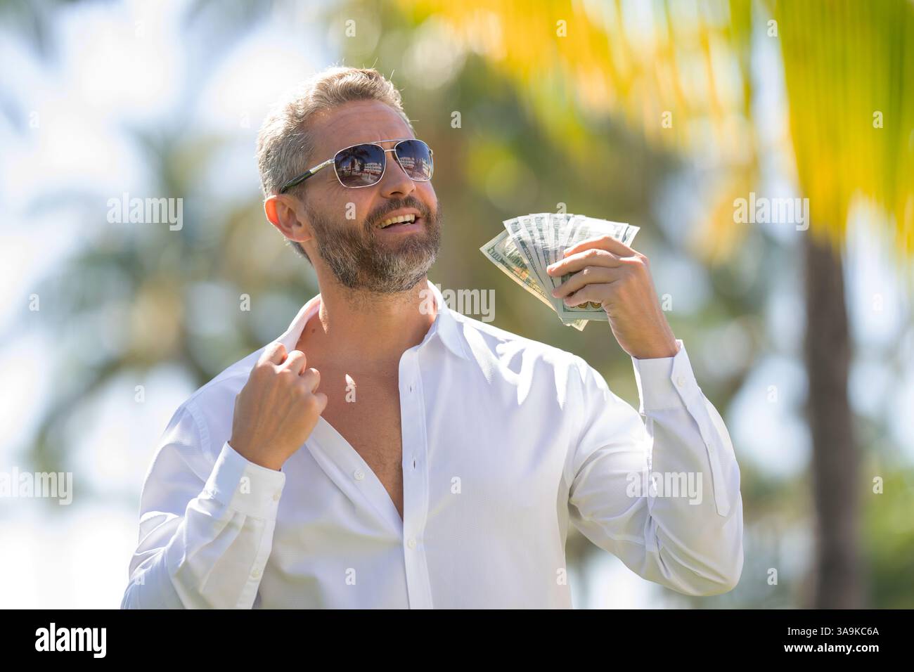 Rich businessman holding cash. Successful rich man counting dollar ...