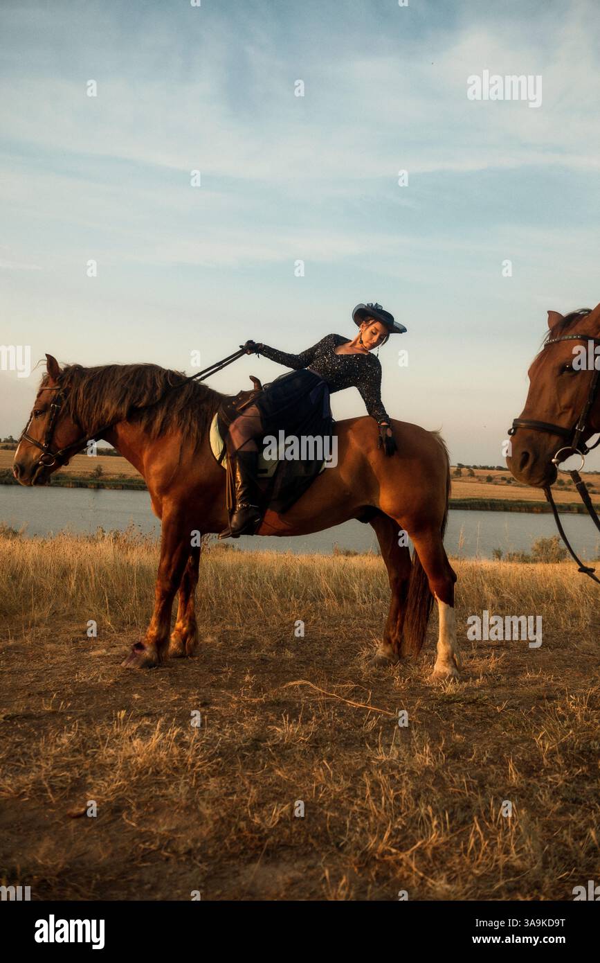 beautiful equestrian woman is engaged in horseback riding Stock Photo ...