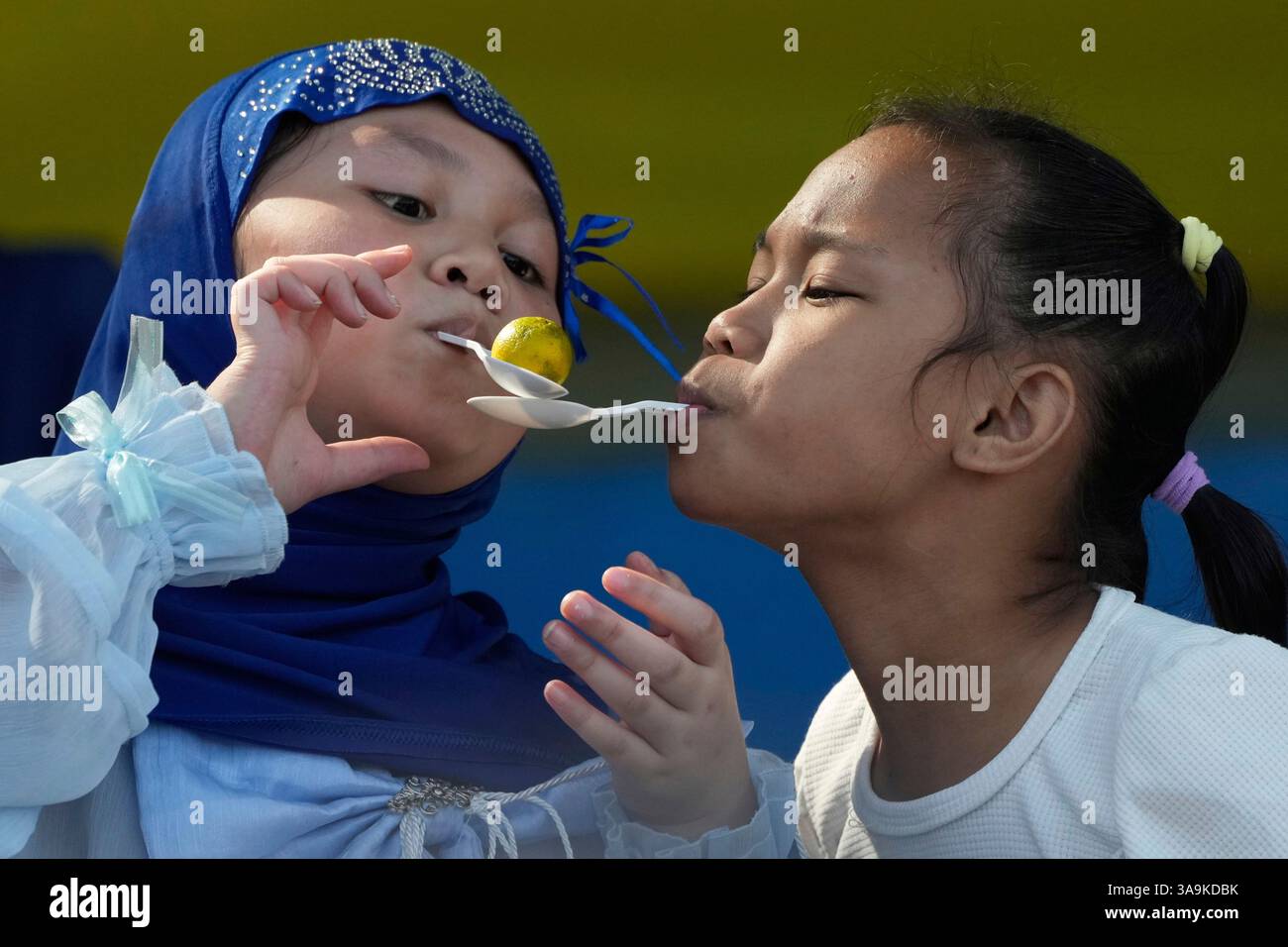 Muslim girls transfer Philippine lime using plastic spoons during a ...