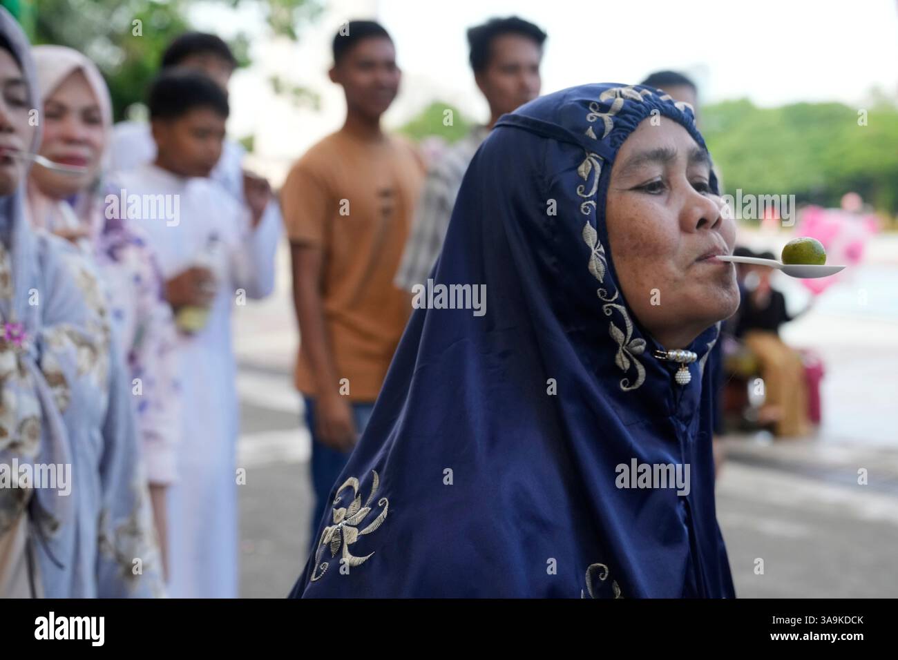 Muslims transfer Philippine lime using plastic spoons during a game as ...