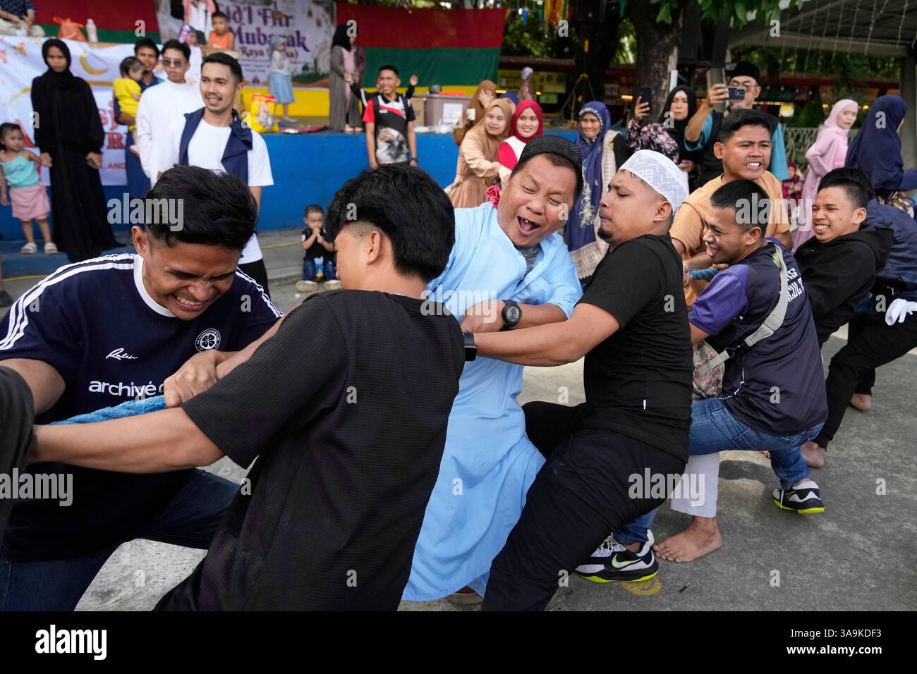 Muslims play a tug-of-war game as they celebrate Eid al-Fitr at a park ...