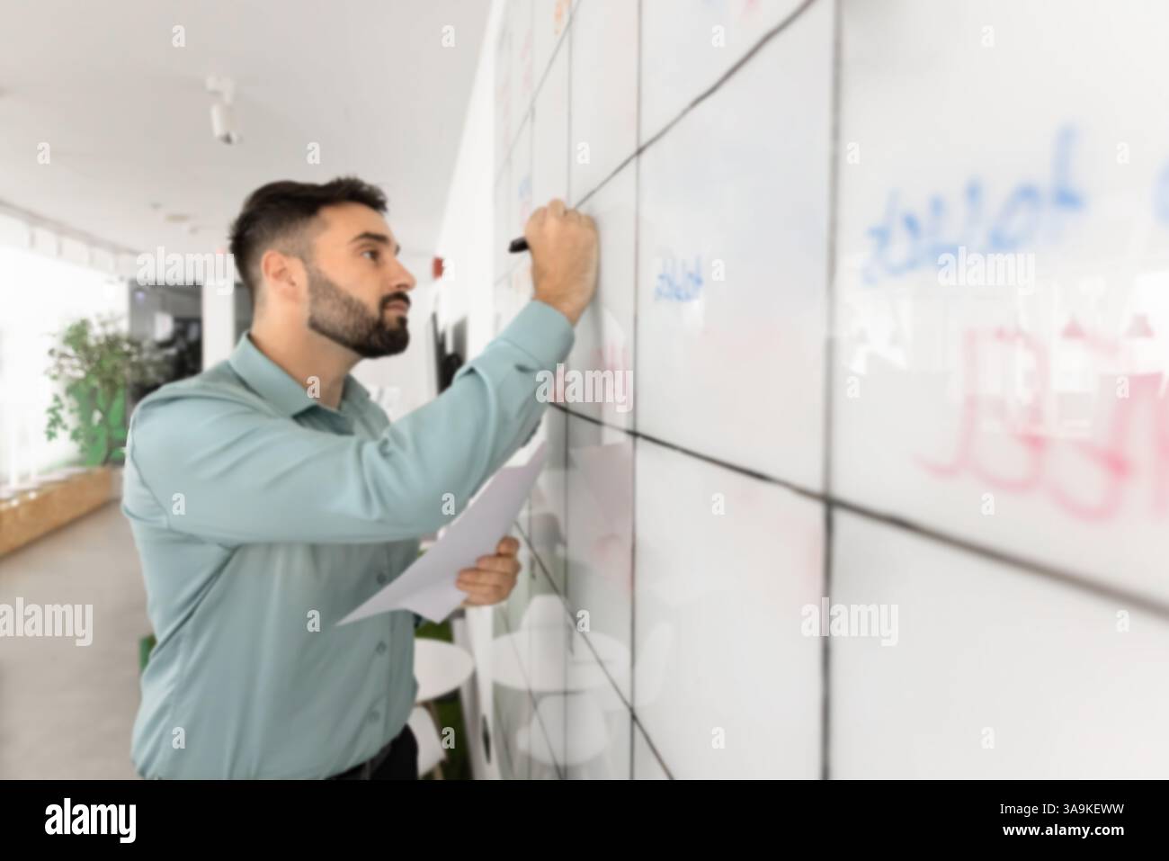 Serious Latin project leader man writing on scrum management board ...