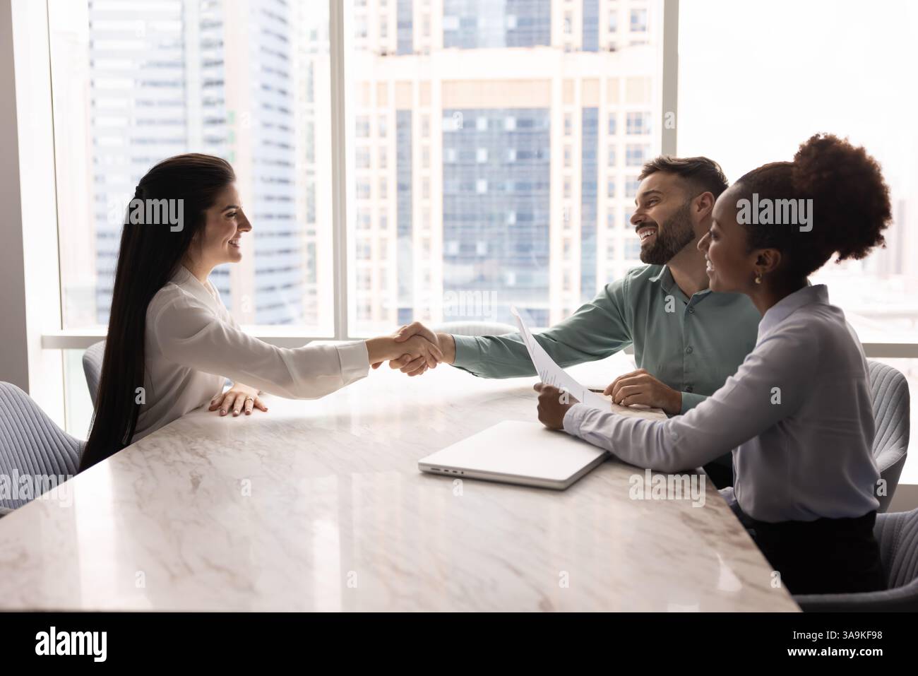Happy diverse recruit team giving handshake to positive job candidate ...