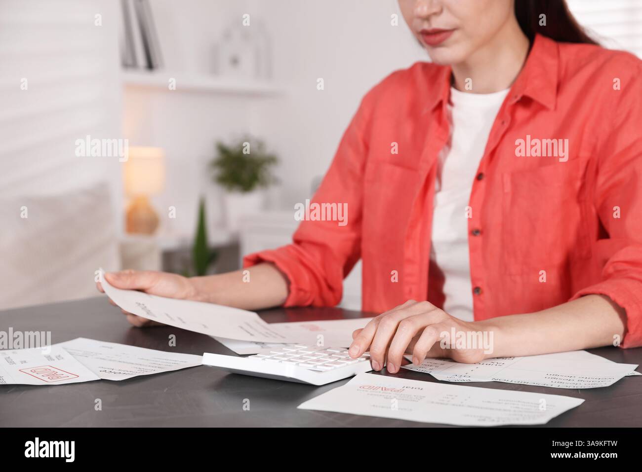 Paying bills. Woman with calculator and invoices at table indoors Stock ...