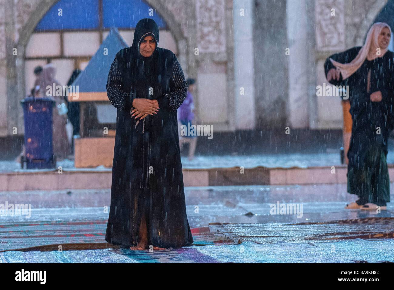 An Iraqi woman pray on the first day of Eid al-Fitr prayers at the ...