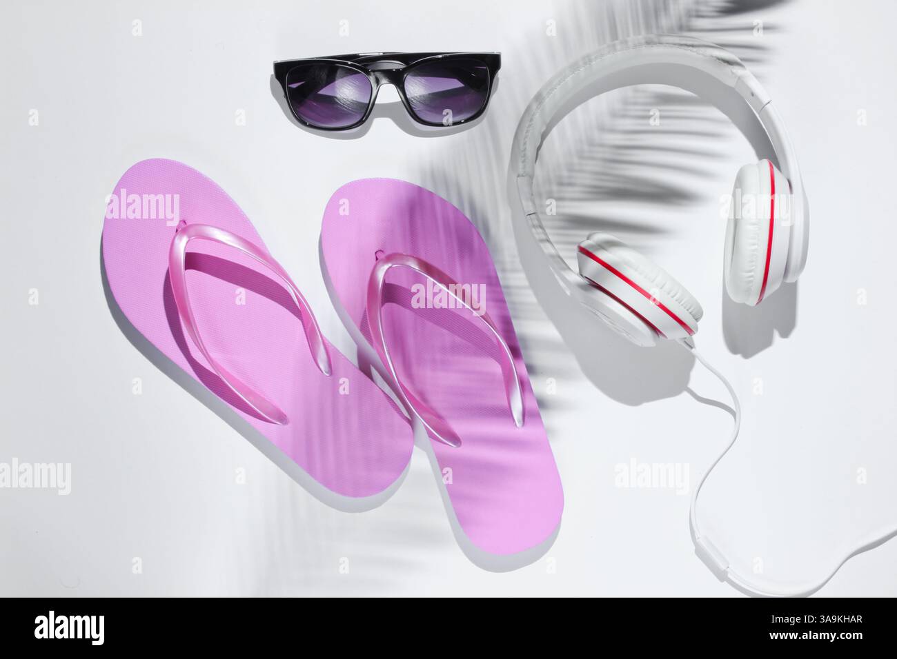 Accessories for relaxing on the beach. Flip flops, headphones, sunglasses. Studio shot on white ...