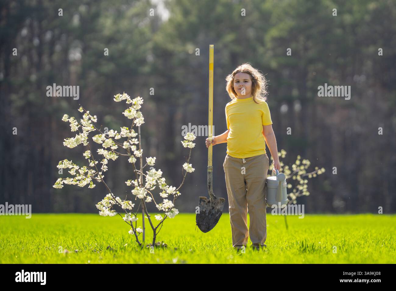 Child working in garden. Growth tree and care plant in garden ...