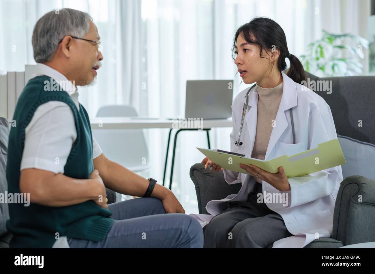 Doctor Talking to Senior Patient with Stomach Pain During Health ...