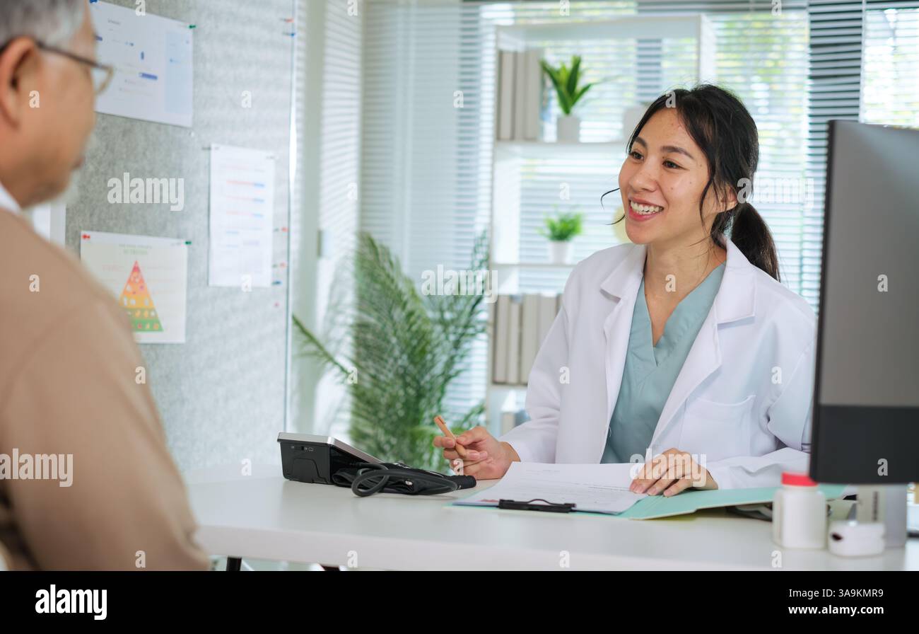 Doctor Reviewing Medical File While Interviewing Elderly Patient at ...