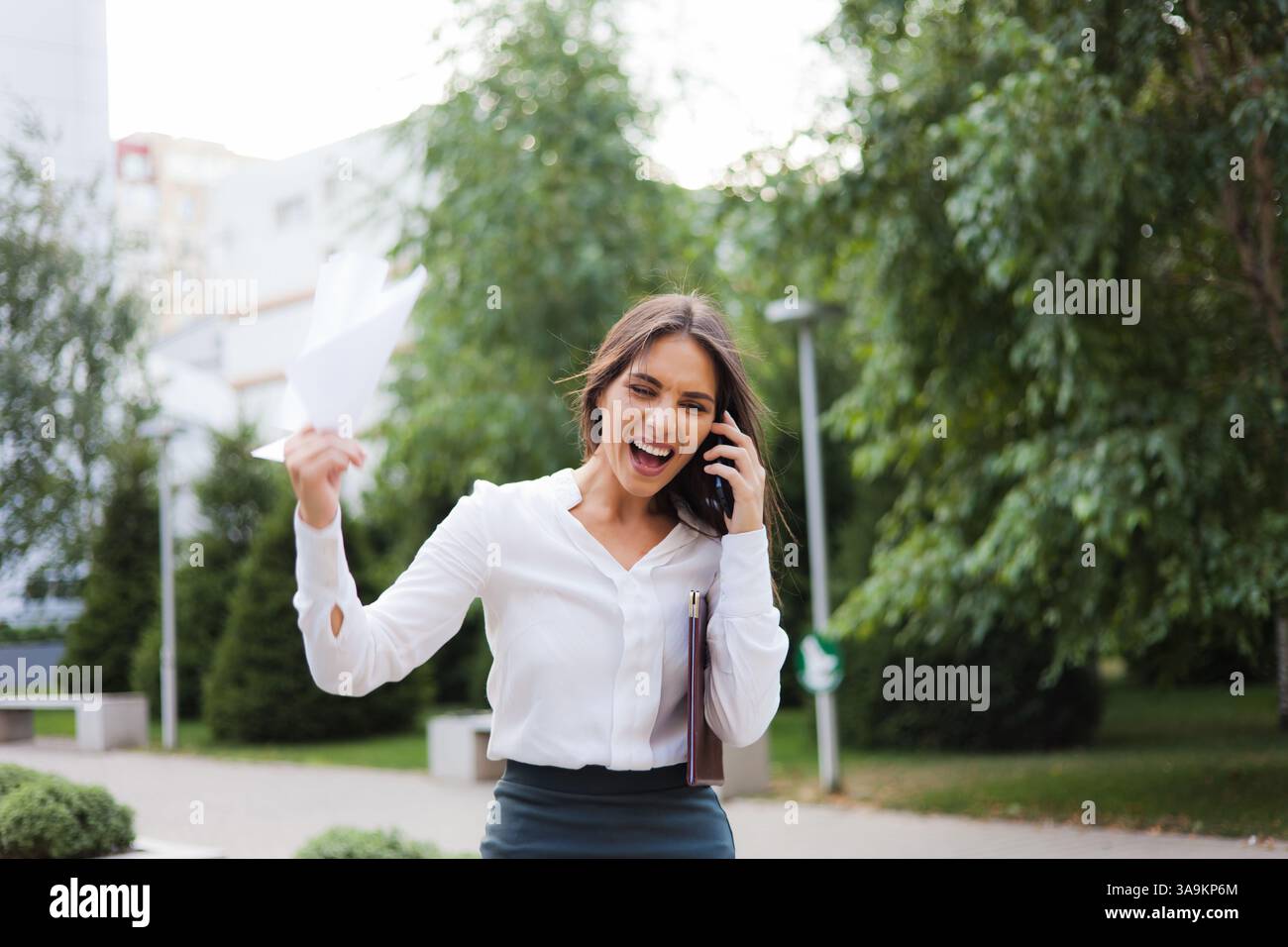 Brought to hysteria, angry business woman dressed in a white blouse and ...