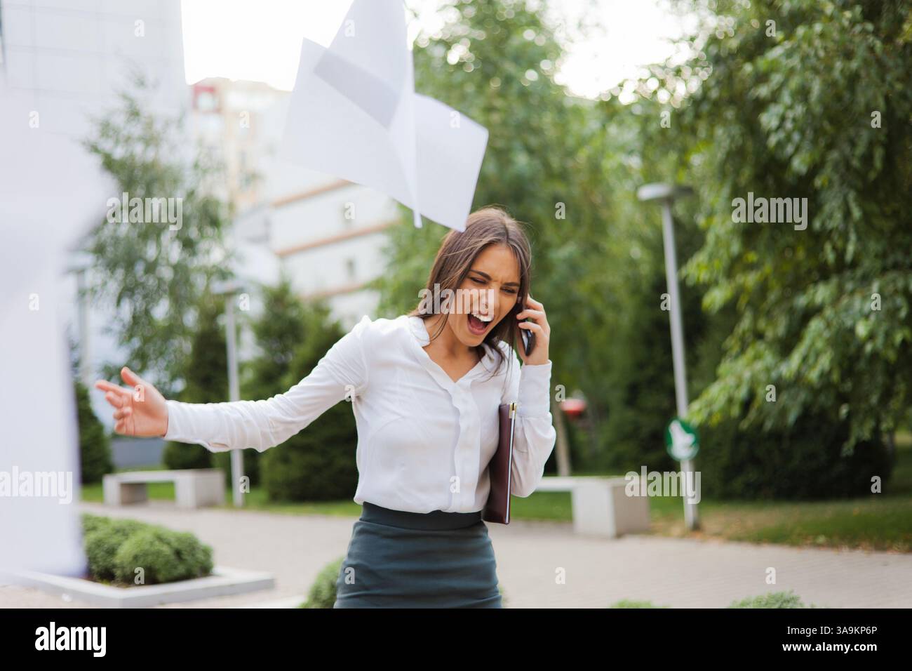 Brought to hysteria, angry business woman dressed in a white blouse and ...