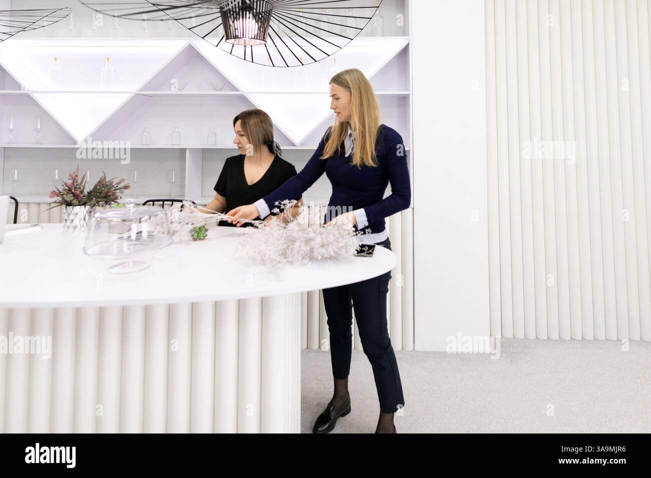 Women teaching floral arrangement techniques in a modern design studio ...