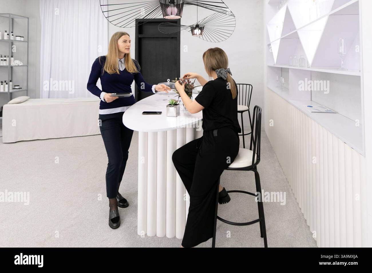 Two women engaging in conversation at a modern interior space during a ...