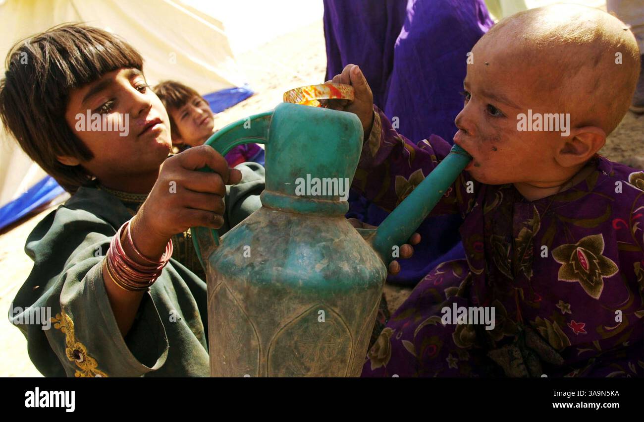 Oct 24, 2001; Chaman, PAKISTAN; An Afghan refugee girl helps her sister ...