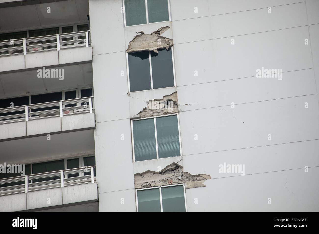 Jagged cracks scar the exterior of a high-rise condominium in Bangkok ...