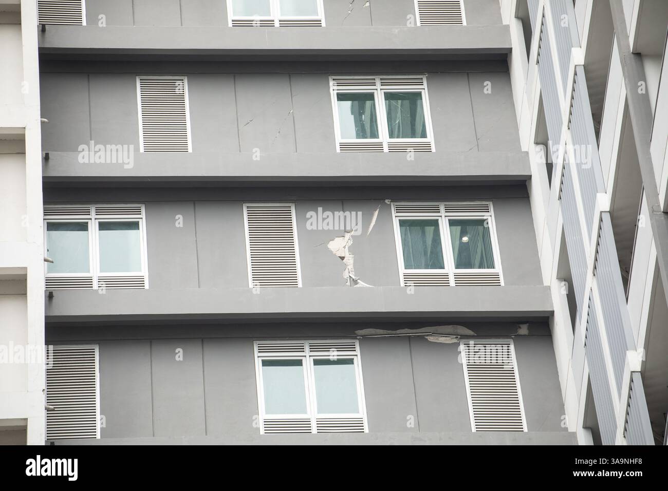 Jagged cracks scar the exterior of a high-rise condominium in Bangkok ...