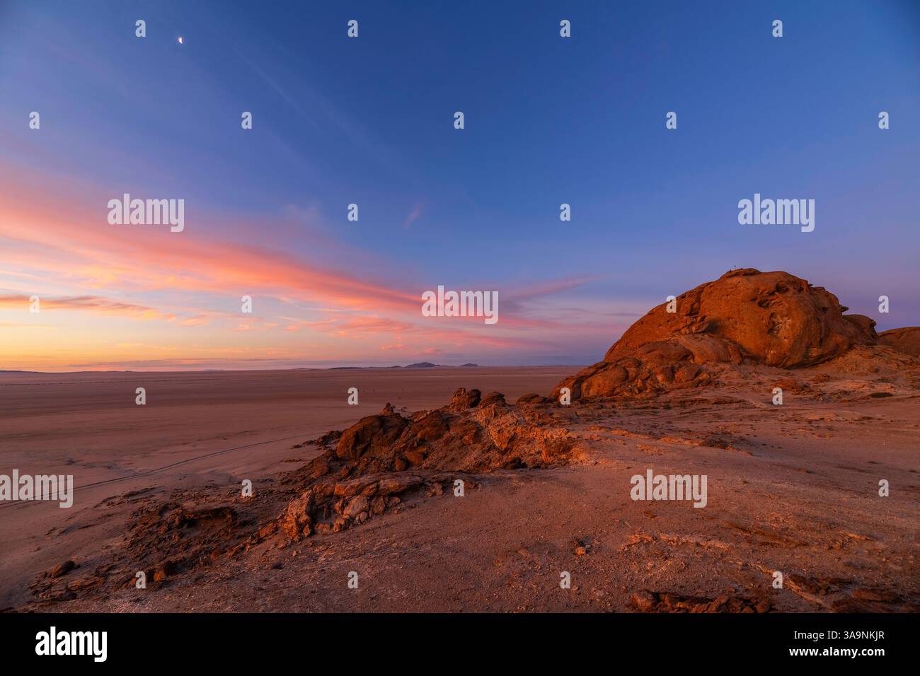 A stunning sunset over the flat desert plains of the Namib Naukluft ...