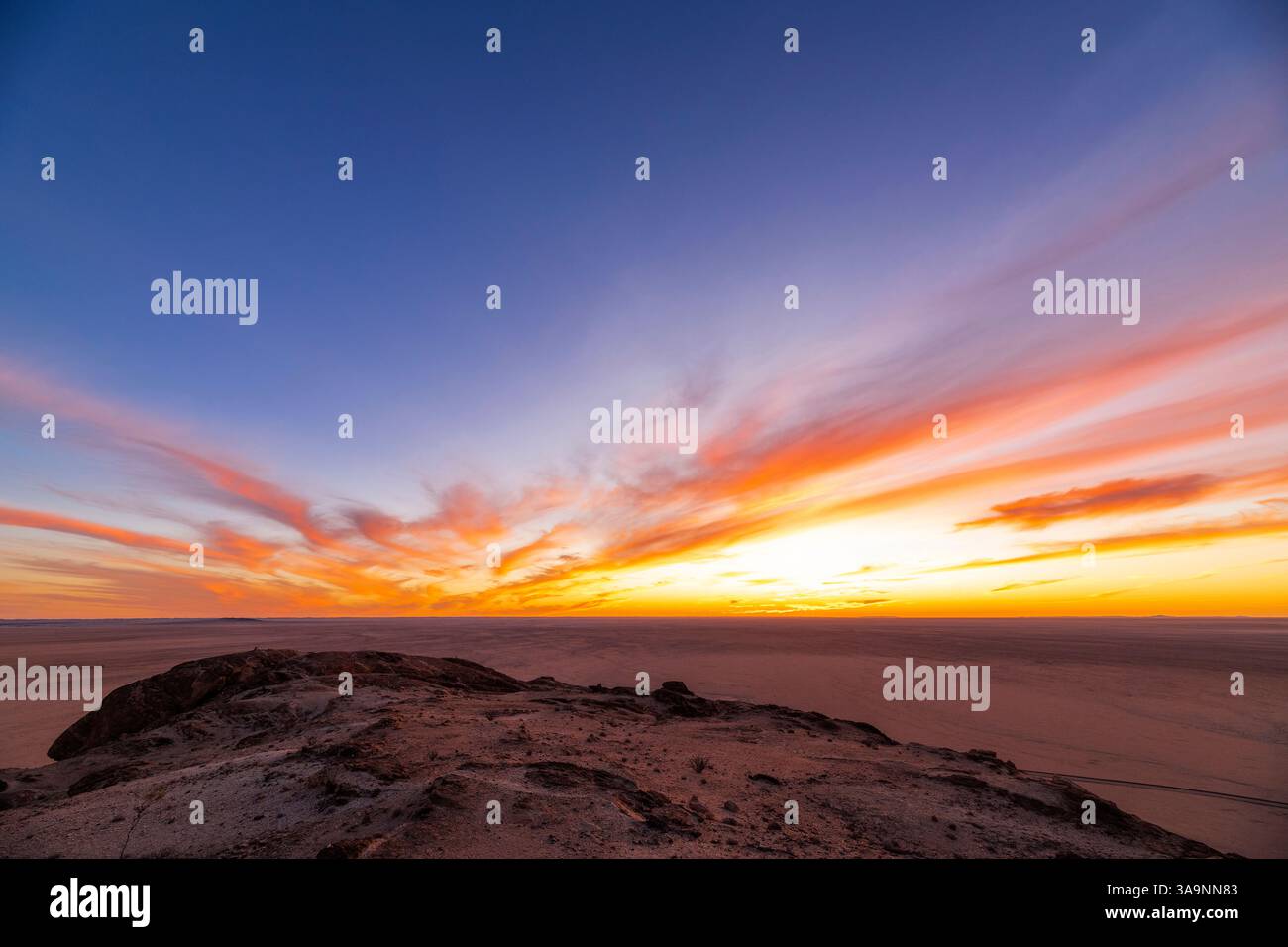 A stunning sunset over the flat desert plains of the Namib Naukluft ...