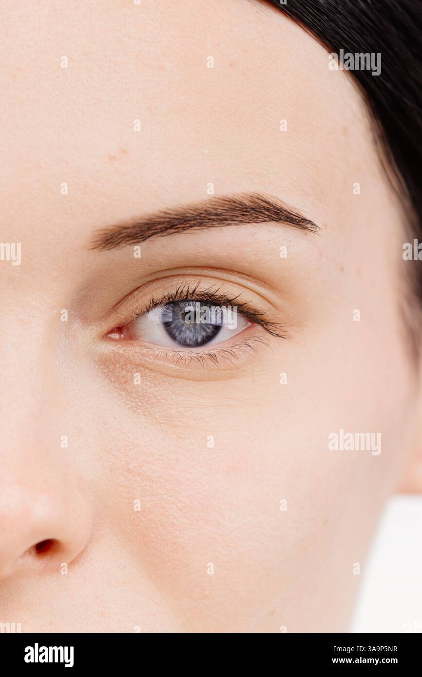 A close-up of a young woman's blue eyes, sparkling with health and ...
