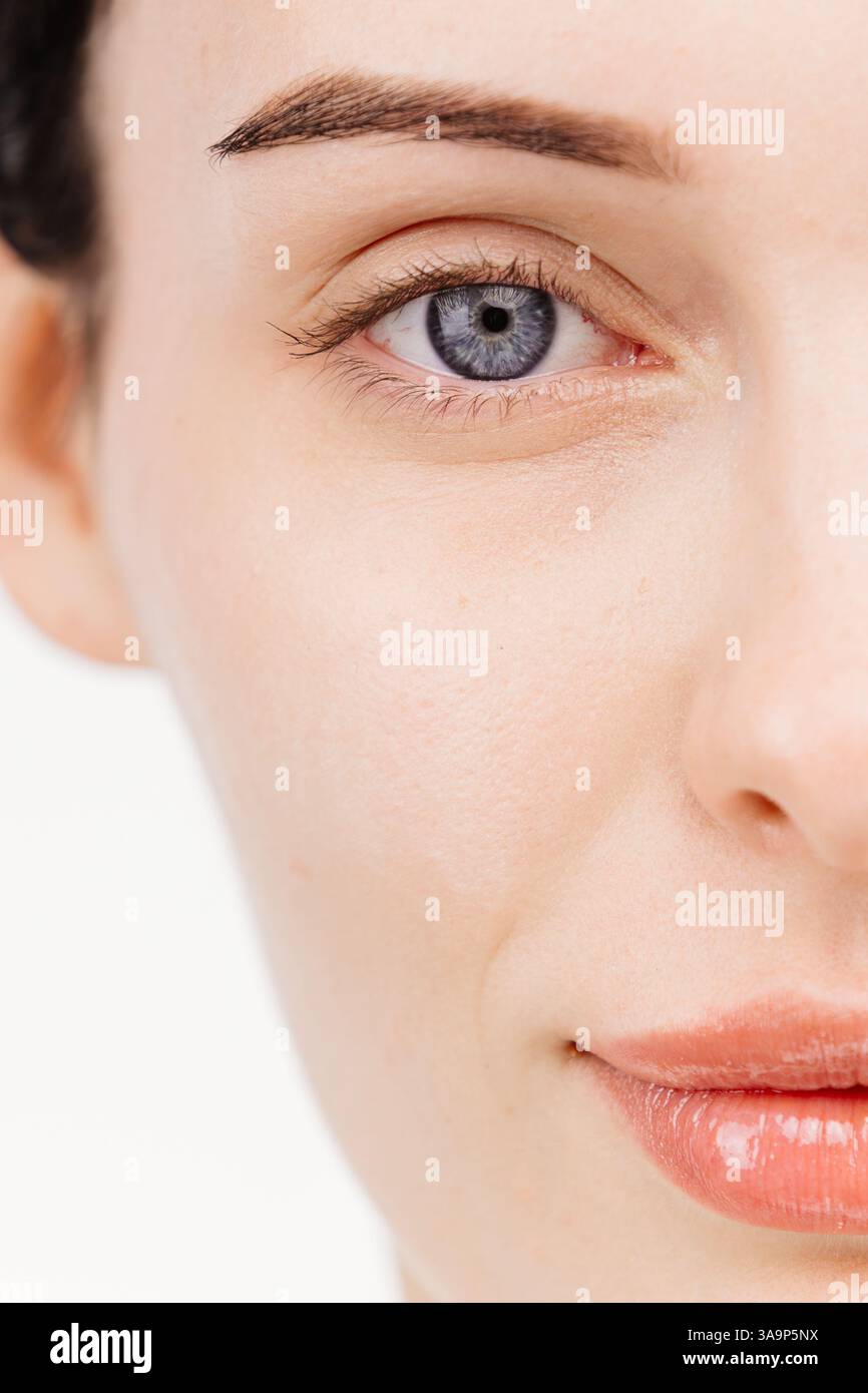 A close-up of a young woman's blue eyes, sparkling with health and ...