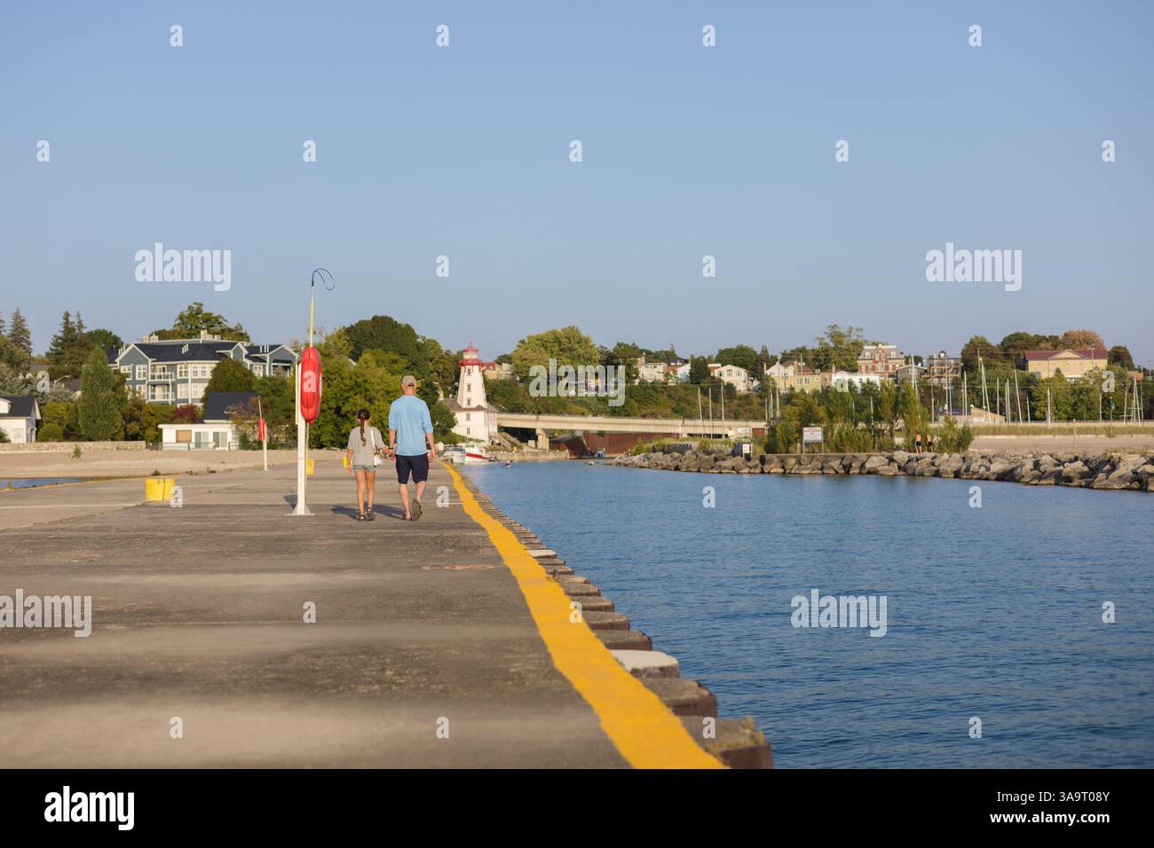 Father and daughter walk along Kincardine dock by lighthouse Stock ...