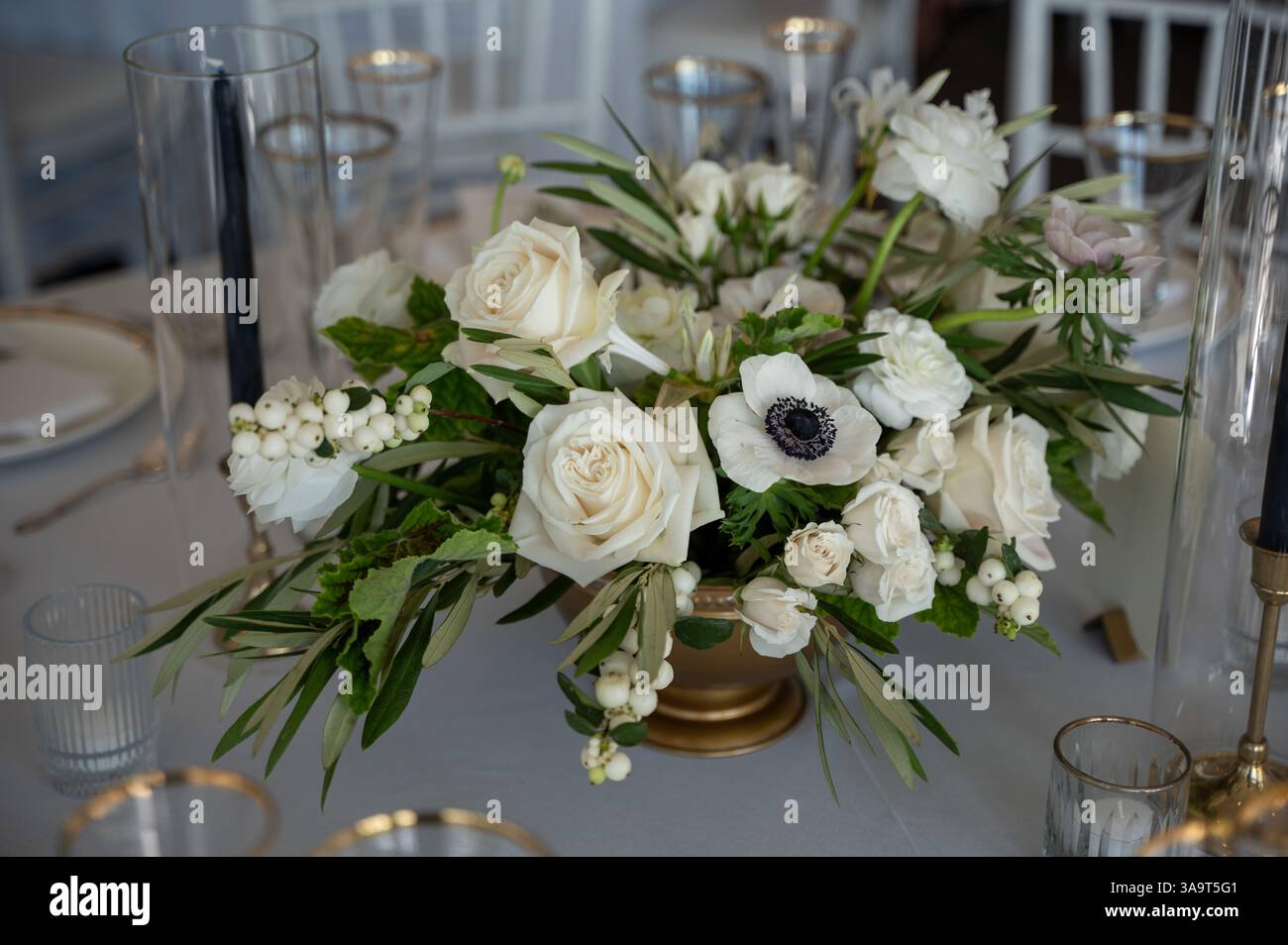 A luxurious white floral centerpiece with roses and anemones Stock ...