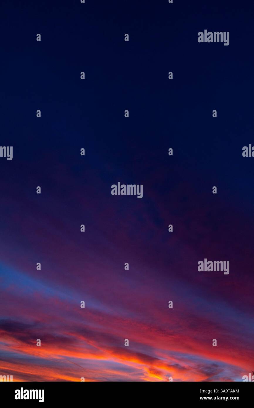 Deep twilight sky, vivid streaks of orange, pink, and indigo clouds ...