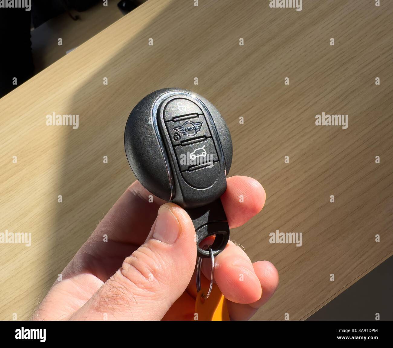 Paris, France - Mar 27, 2025: A hand holds a MINI key fob with ...