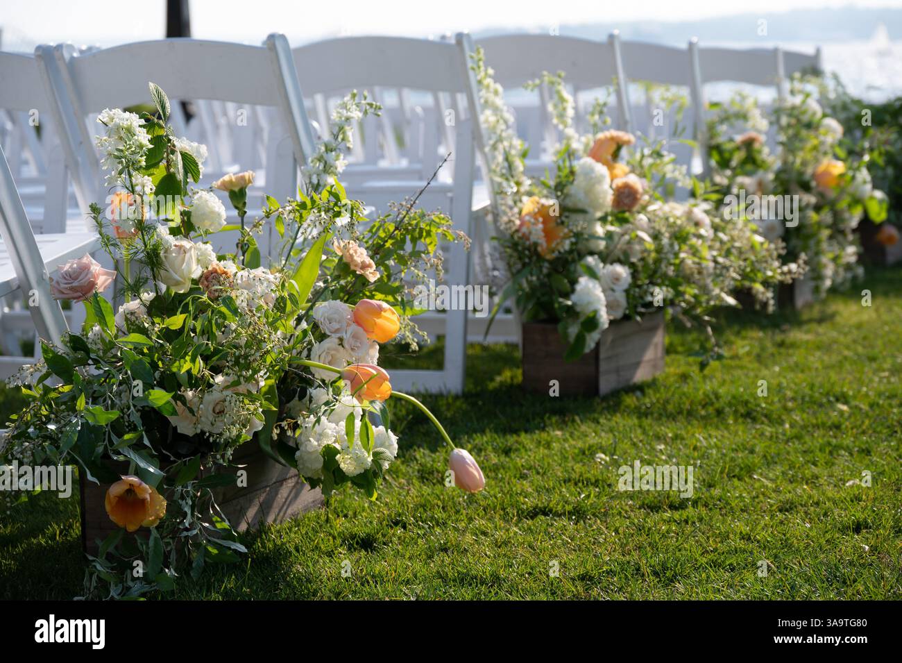 Outdoor wedding aisle with floral arrangements and white ceremon Stock ...