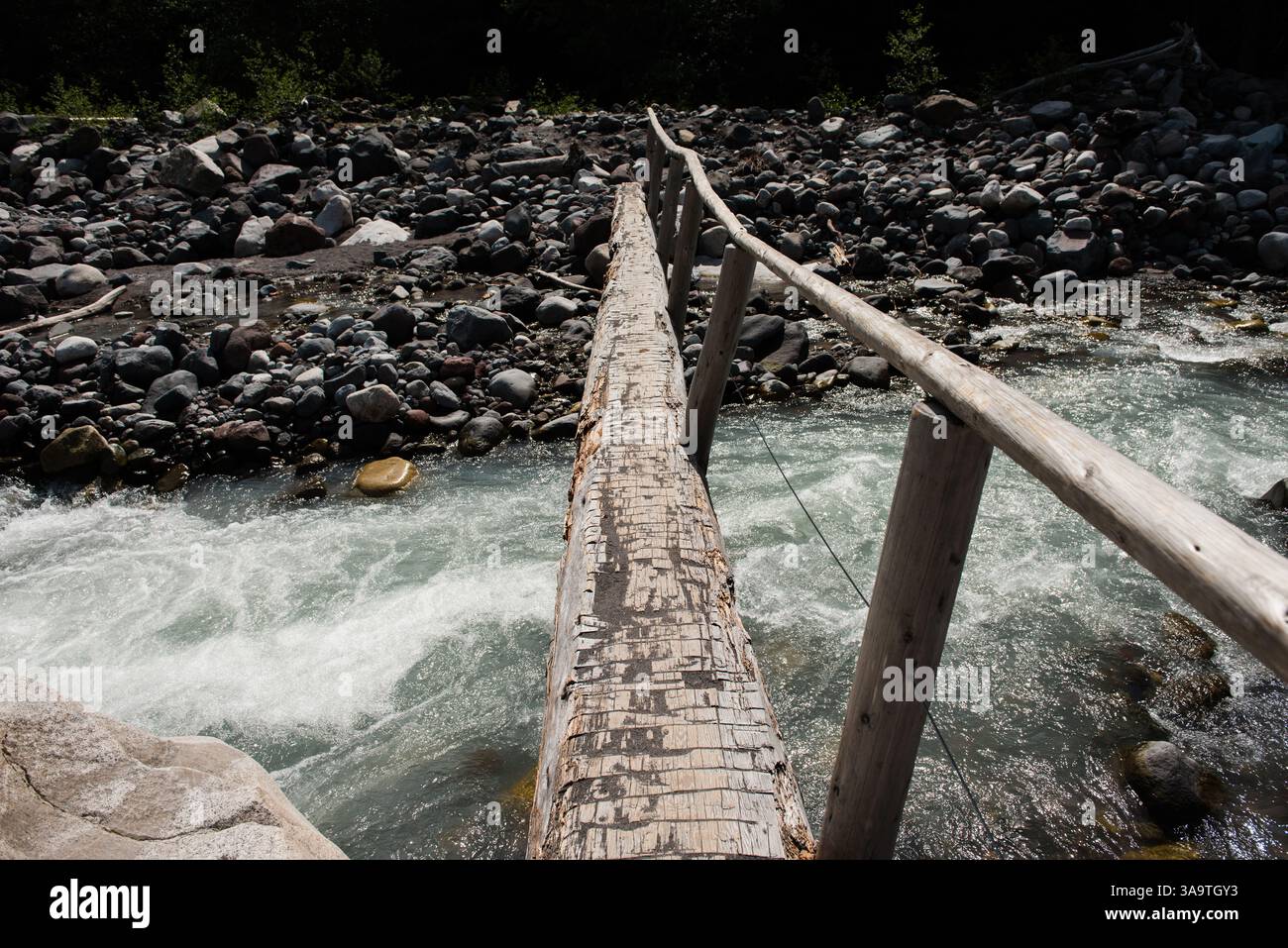 A Log Bridge Over a Rushing River Stock Photo - Alamy