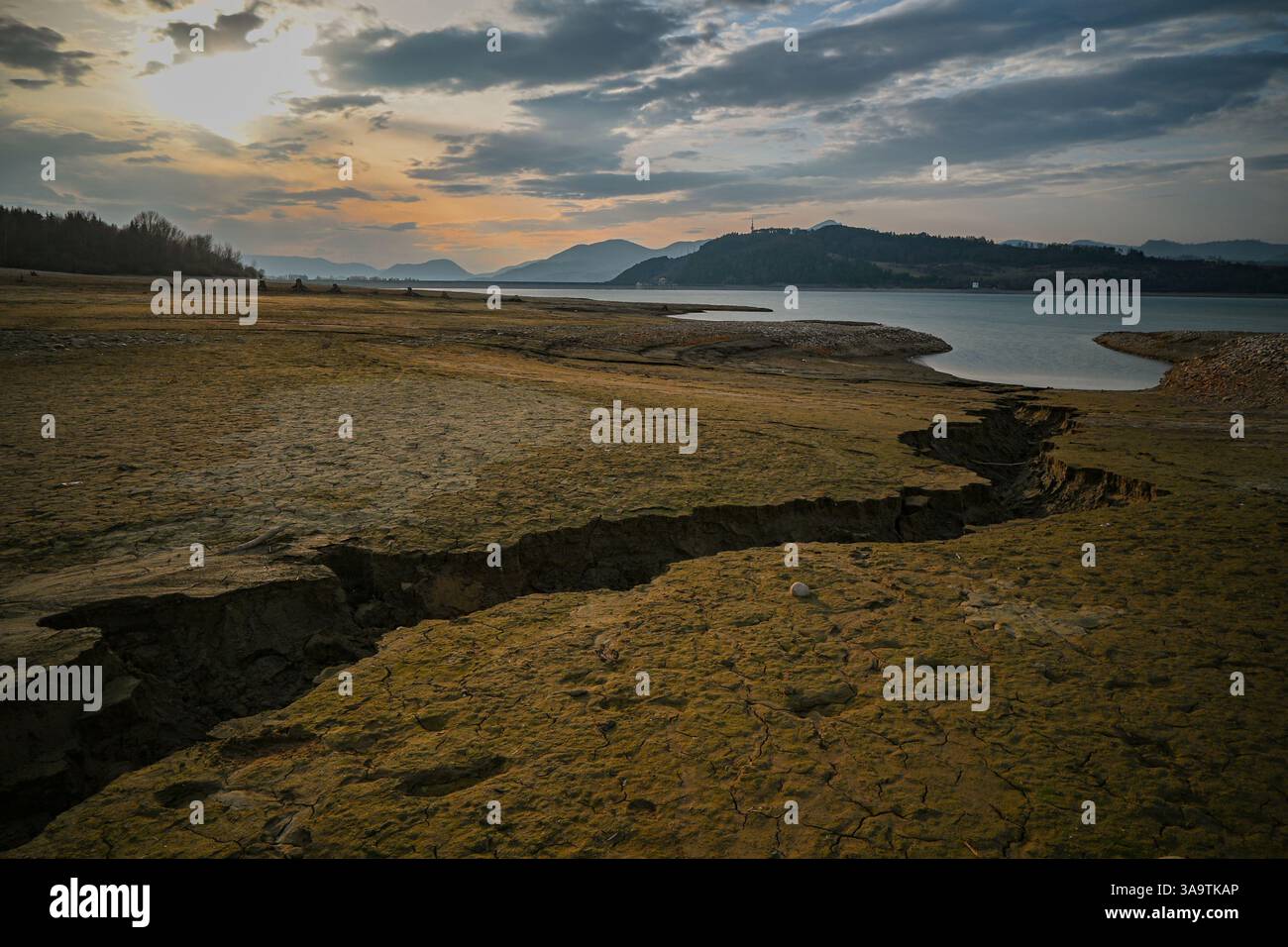 Dry cracked earth and receding water level reveal the dramatic effects ...
