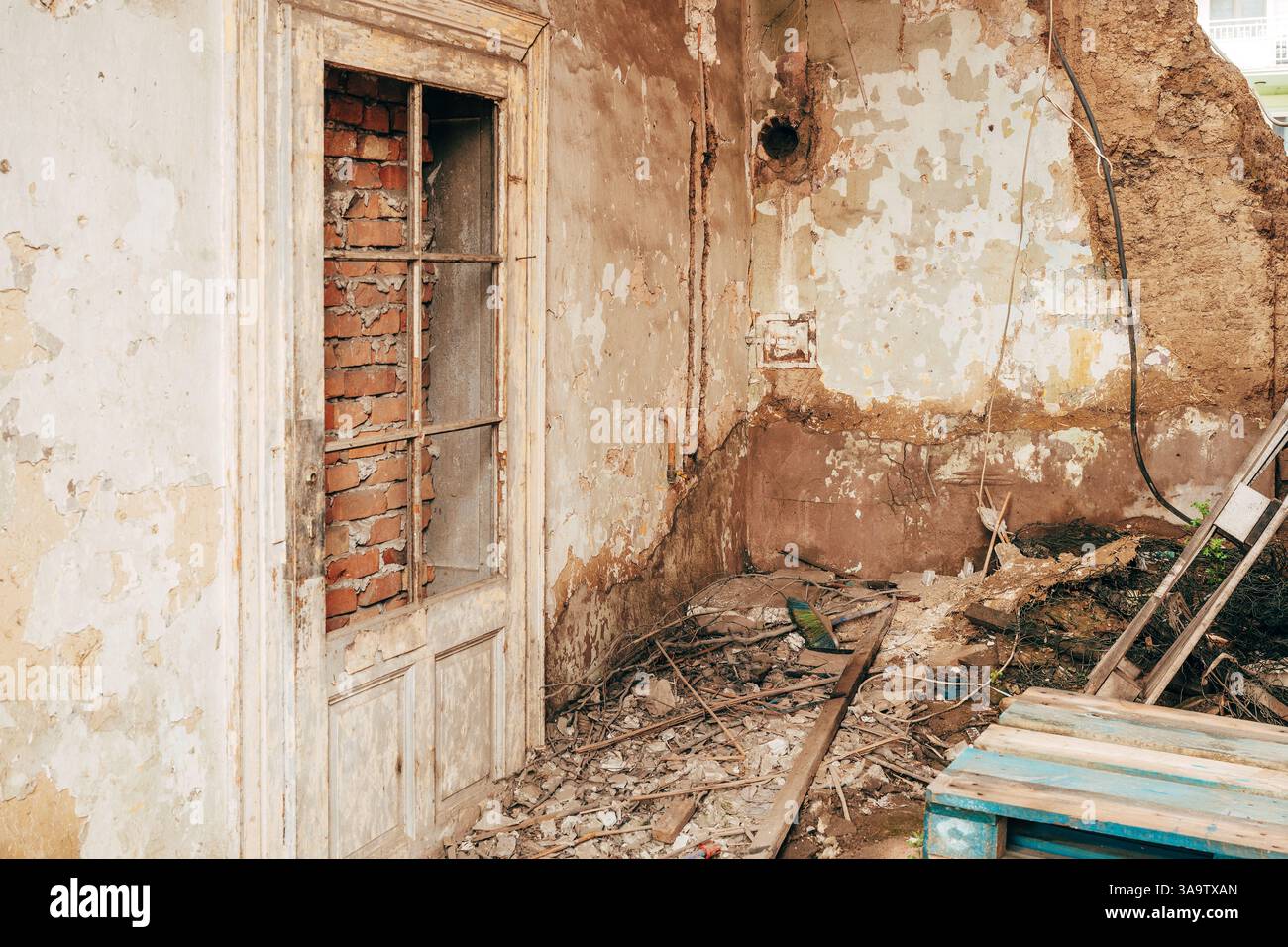 Old ruined house with damaged wall and broken doors, run down building ...