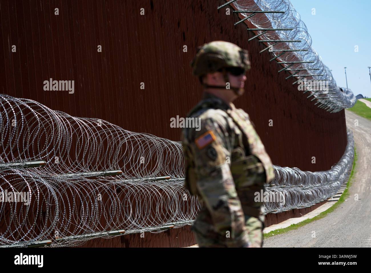 FILE - A member of the military looks on in front of newly-installed ...
