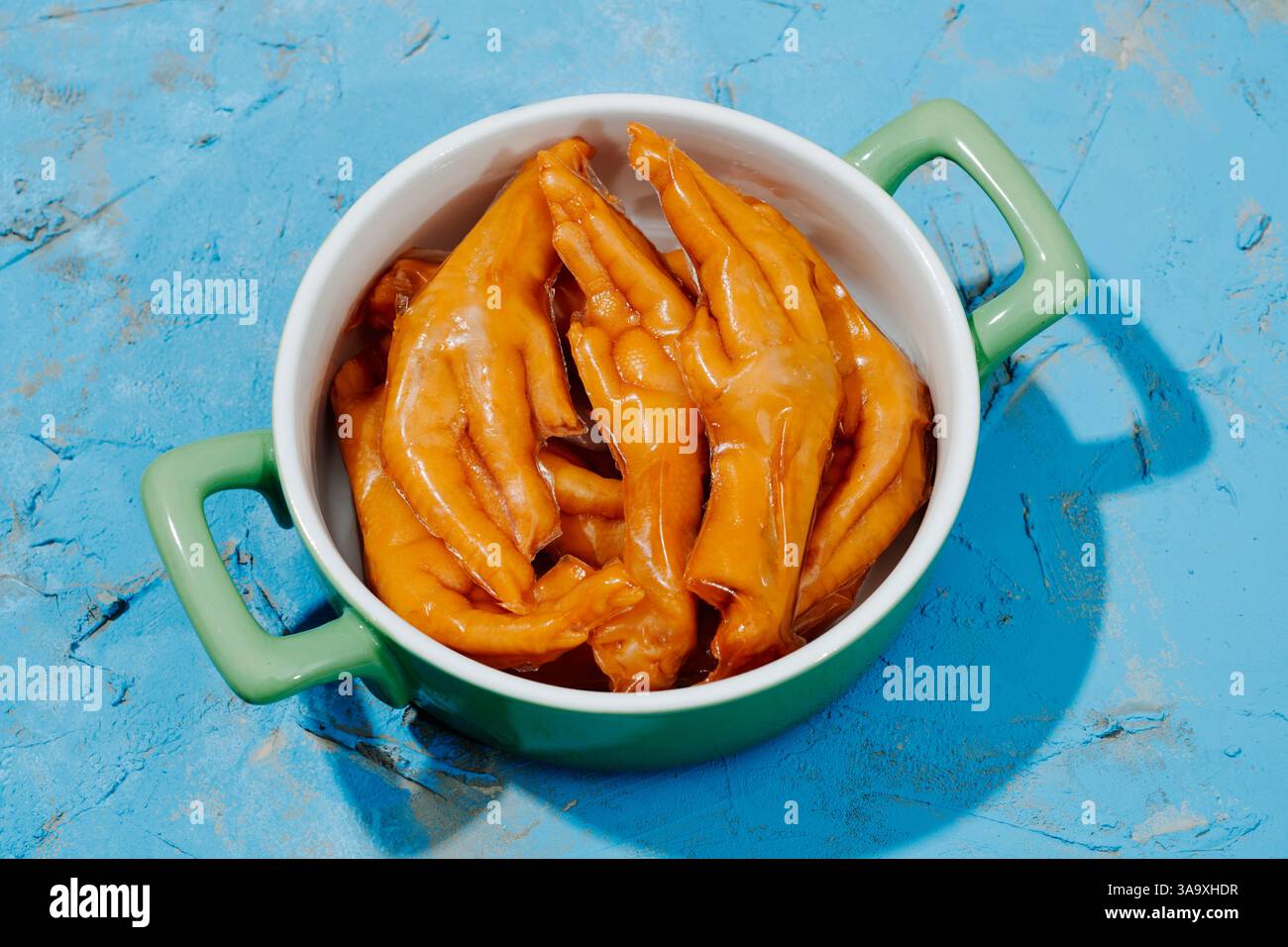 some asian boneless chicken feet coated in gelatin in a pale green ...