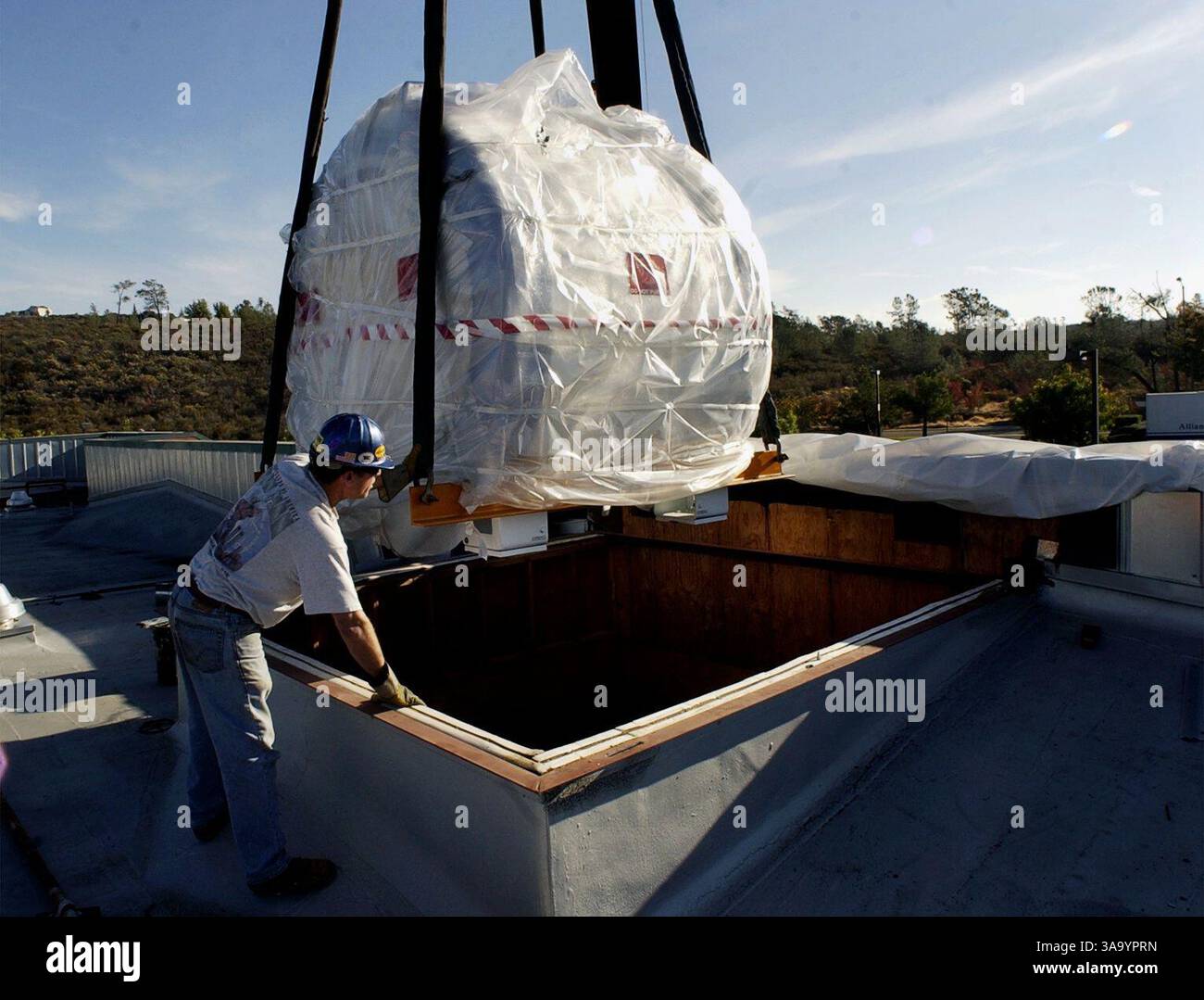 Crane techician Bernard Schmall, cq, guides the 12,000lb. magnet into a ...