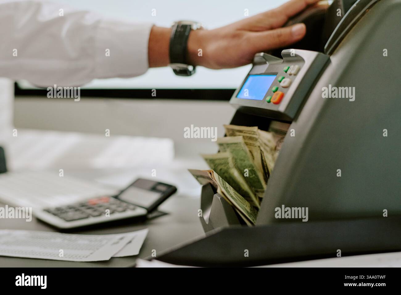 Close-up of person adjusting electronic cash register, with calculator ...