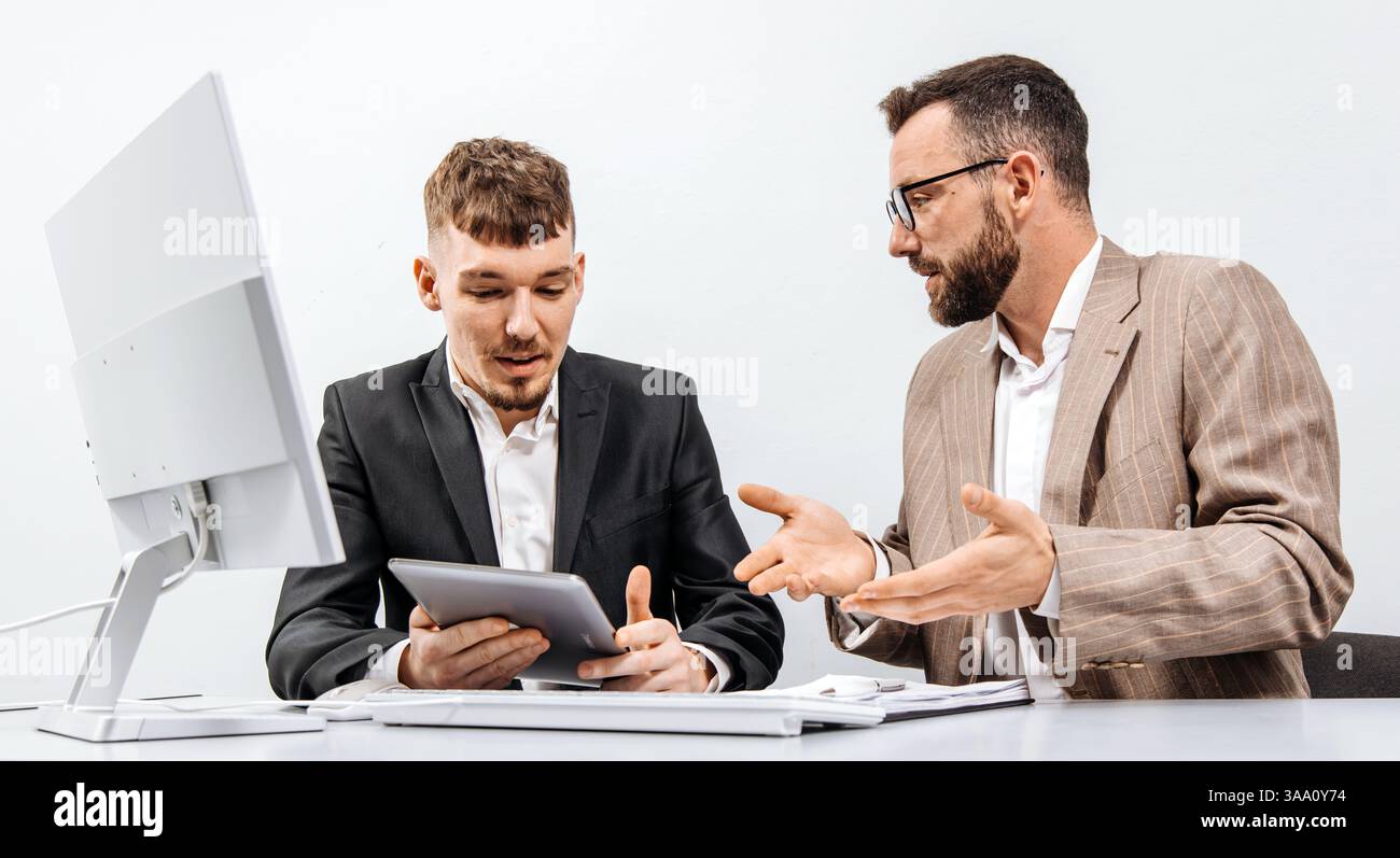 Two business men discuss an online project or presentation at a ...