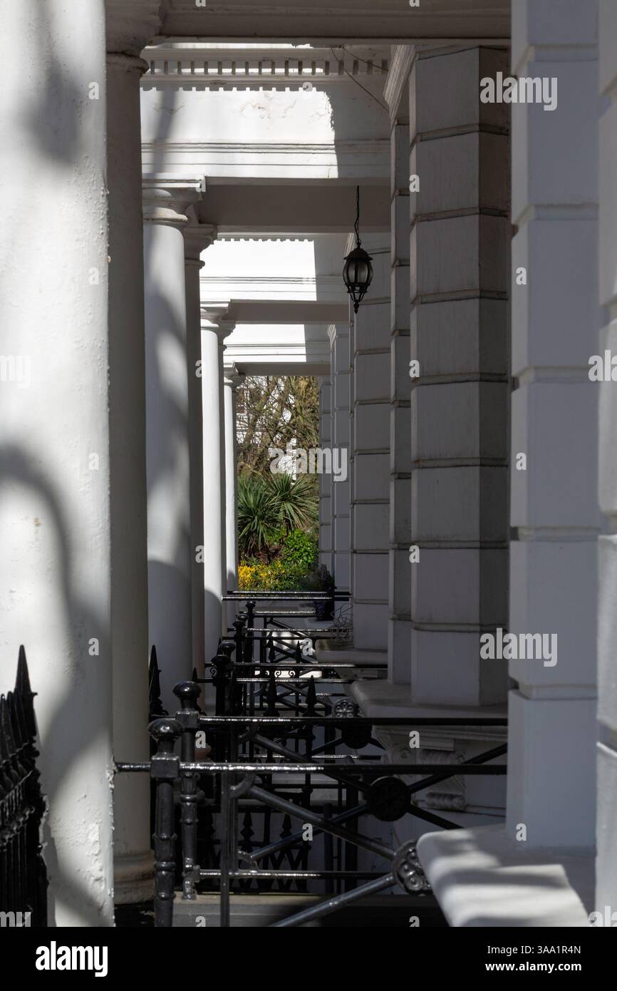 View along terrace of Georgian houses with portico columns and basement ...