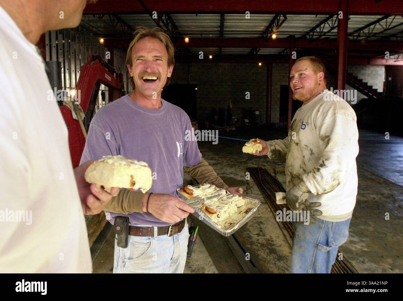 Construction supervisor Michael Rugge, center, serves sweet rolls to ...