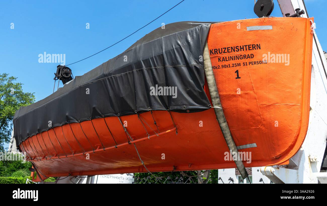 Orange boat from the four-masted barque Kruzenshtern on the embankment ...