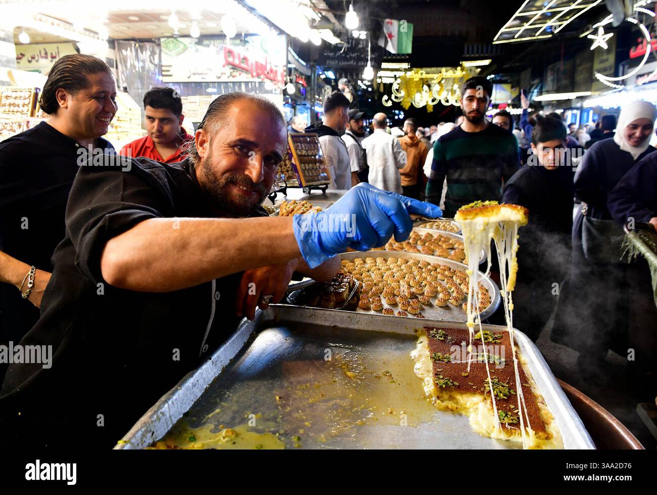 Damascus, Syria. 30th Mar, 2025. A vendor shows his food at a market on ...