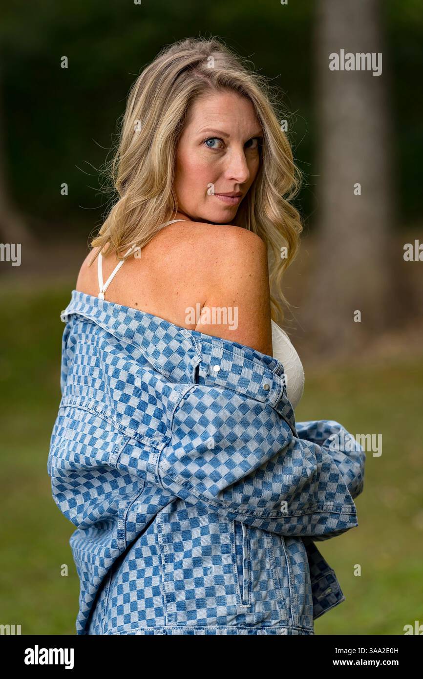 A beautiful blonde model enjoys the late summer sun outdoors ...