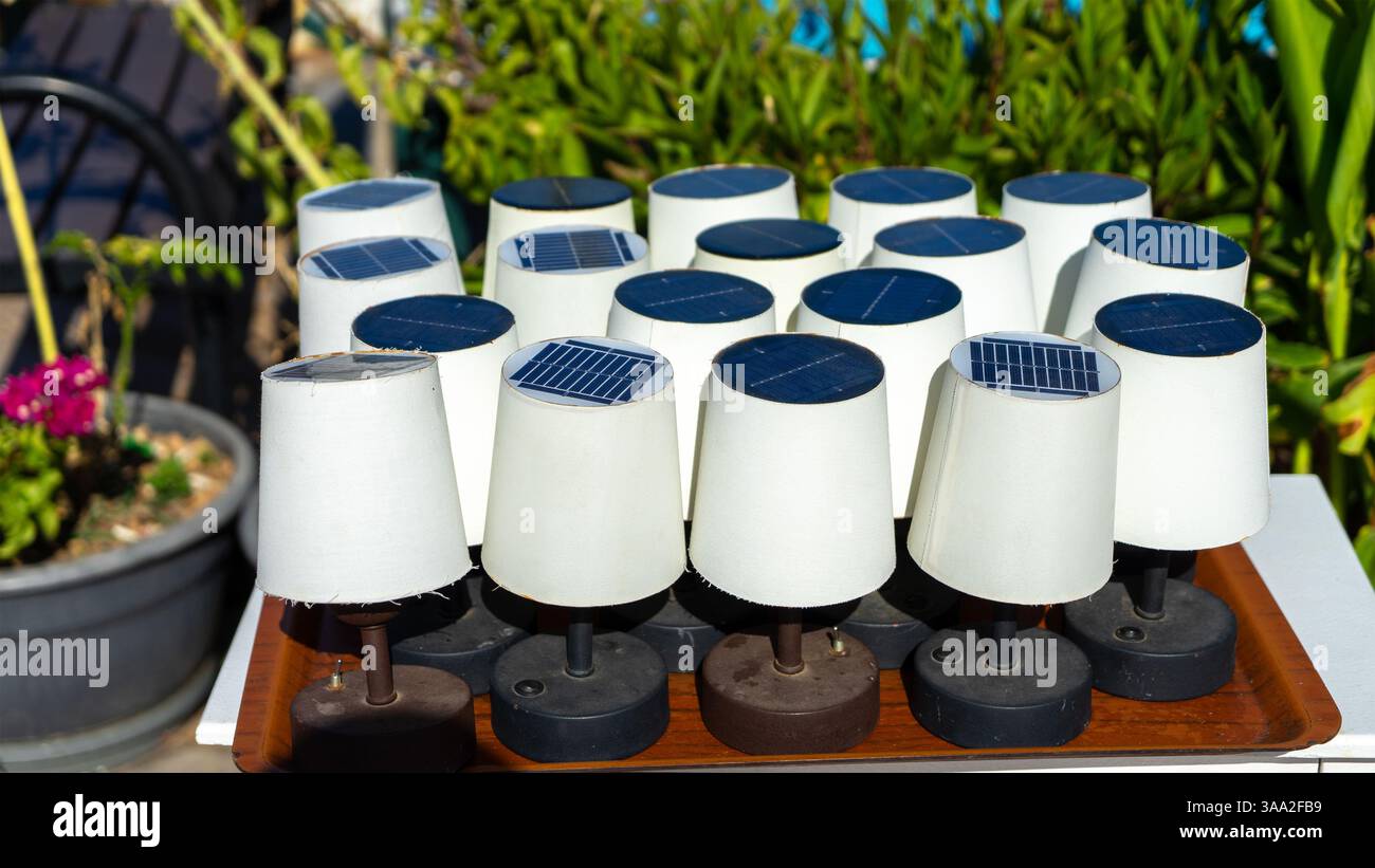 Table lamps with white shades on solar battery are charged from sun ...