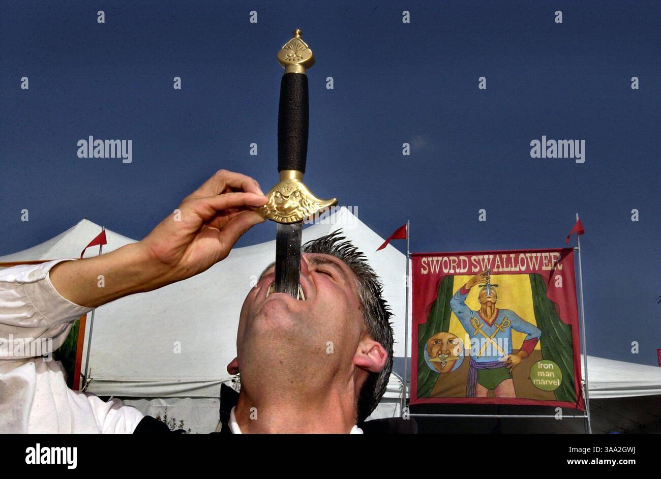 PHOTO FOR SCENE Sword swallower Brad Byers mimics the side show banner ...