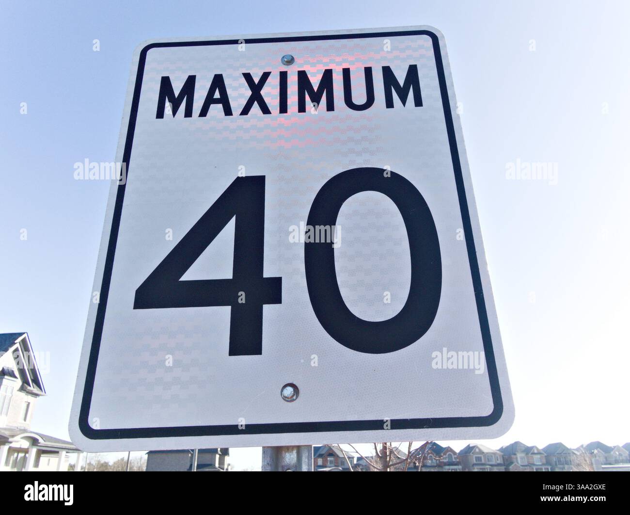 Standing tall against the suburban landscape, this speed limit sign ...