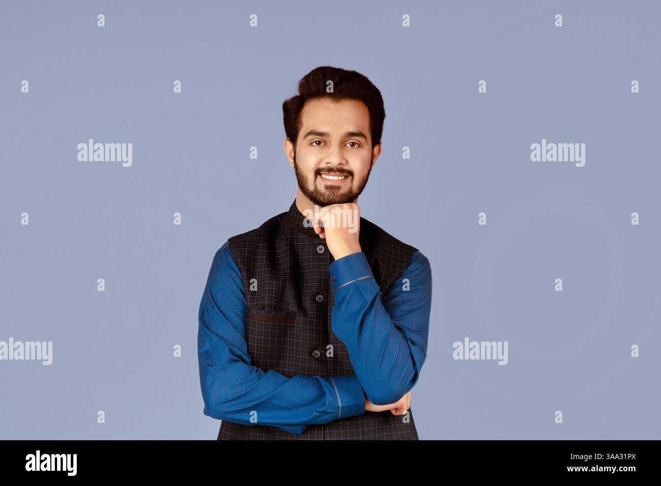 Portrait of attractive Indian man propping chin with his hand on lilac ...