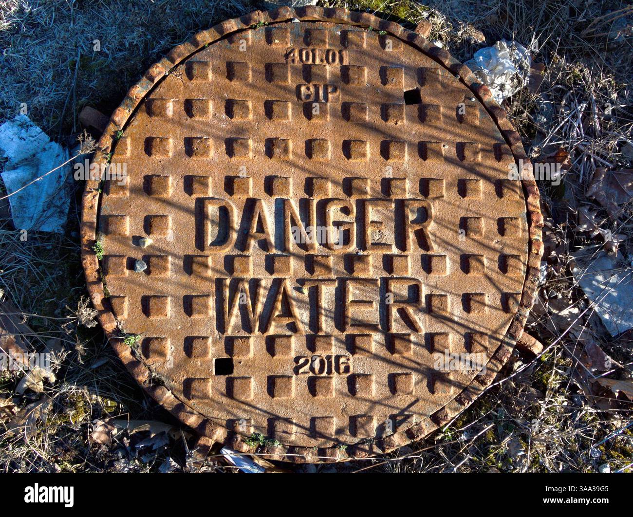 Manhole cover clearly labeled danger water warns pedestrians of ...