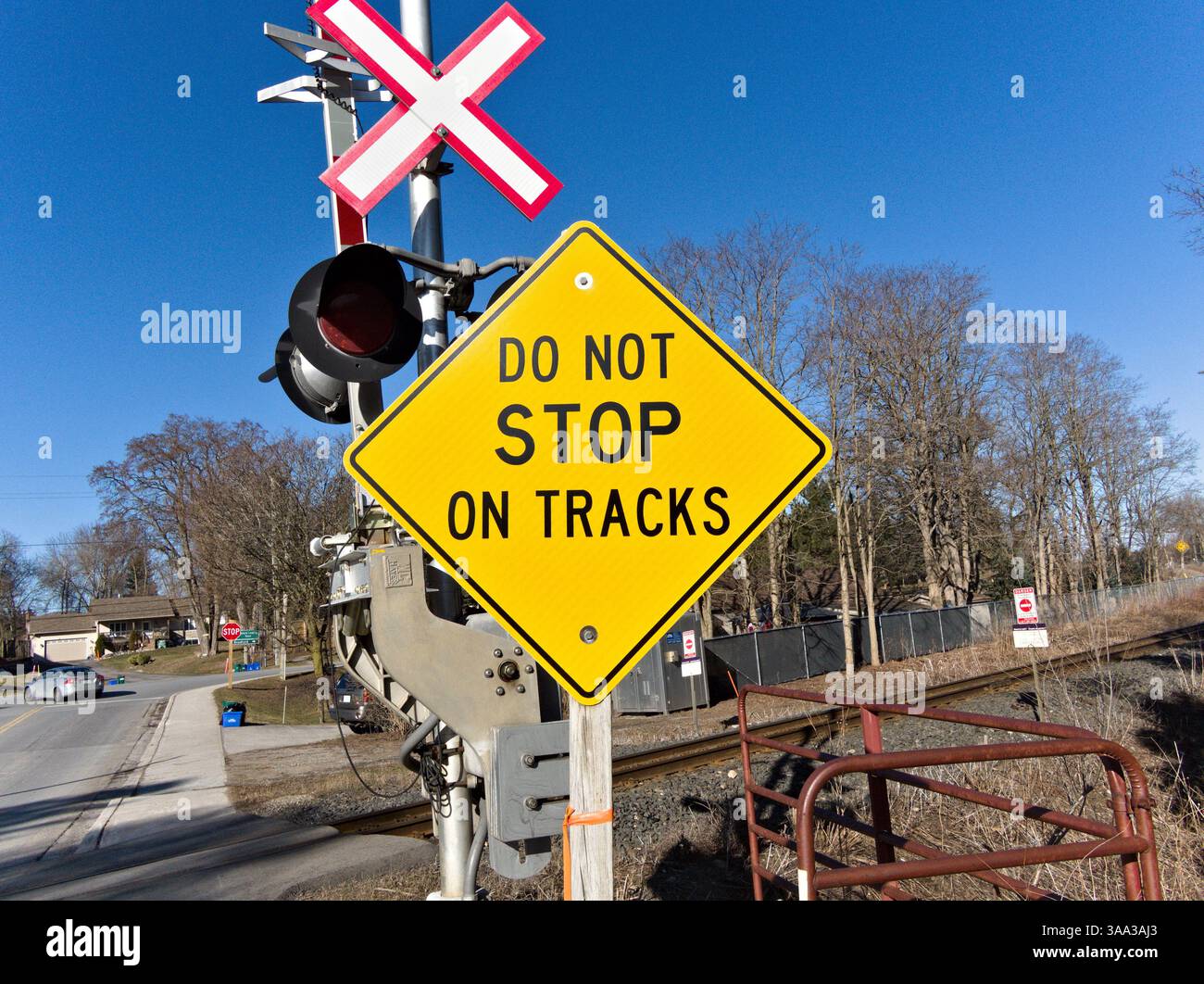 Brightly colored safety sign clearly warns drivers to never stop on ...